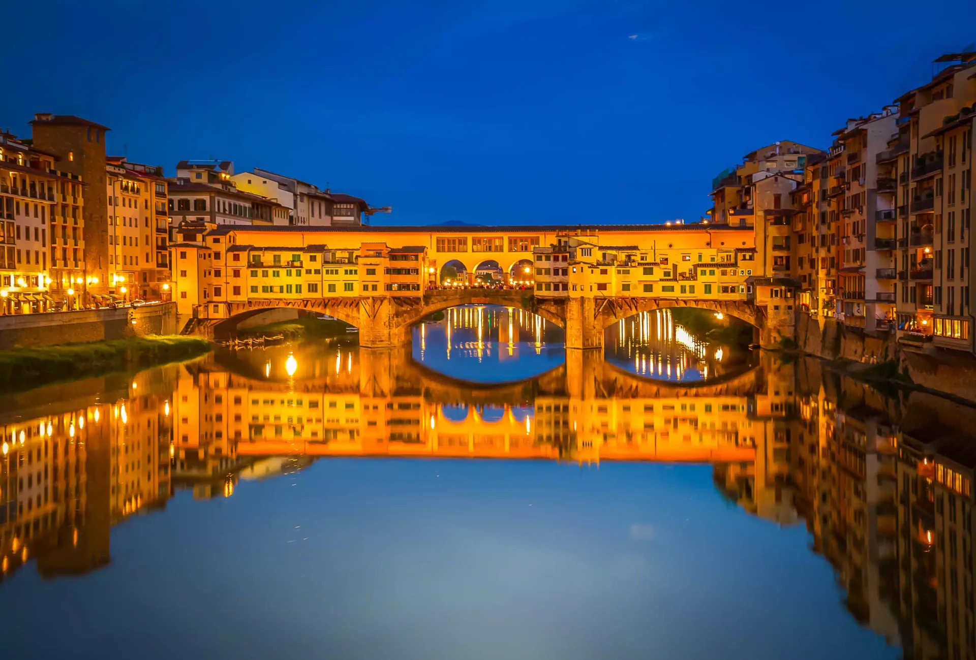 Il famoso Ponte Vecchio che si riflette nel fiume Arno di notte, Firenze, Italia