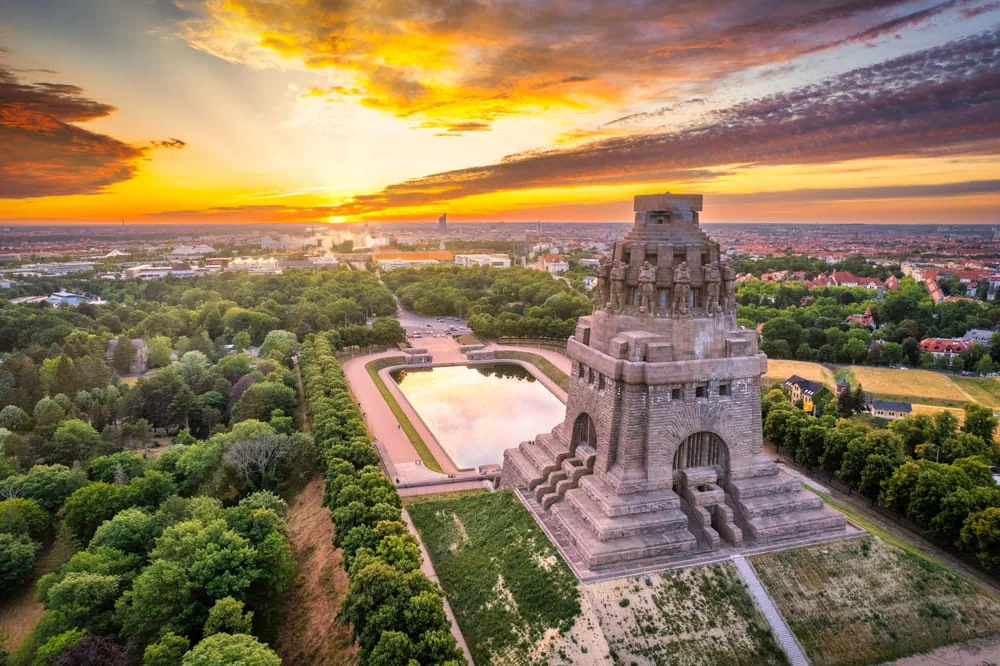 Die Stadt Leipzig mit dem Völkerschlachtdenkmal Panoramablick über die Stadt Leipzig mit dem Völkerschlachtdenkmal bei Sonnenuntergang in Leipzig, Sachsen, Deutschland