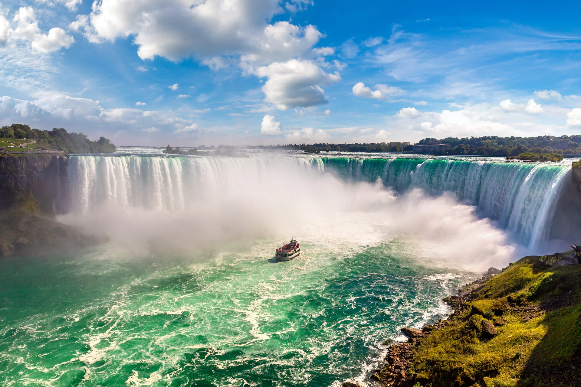 Side view of Horseshoe Falls from the Canadian side, Niagara Falls, Ontario, Canada Side view of Horseshoe Falls from the Canadian side, with sightseeing boats on a sunny day in Niagara Falls, Ontario, Canada.