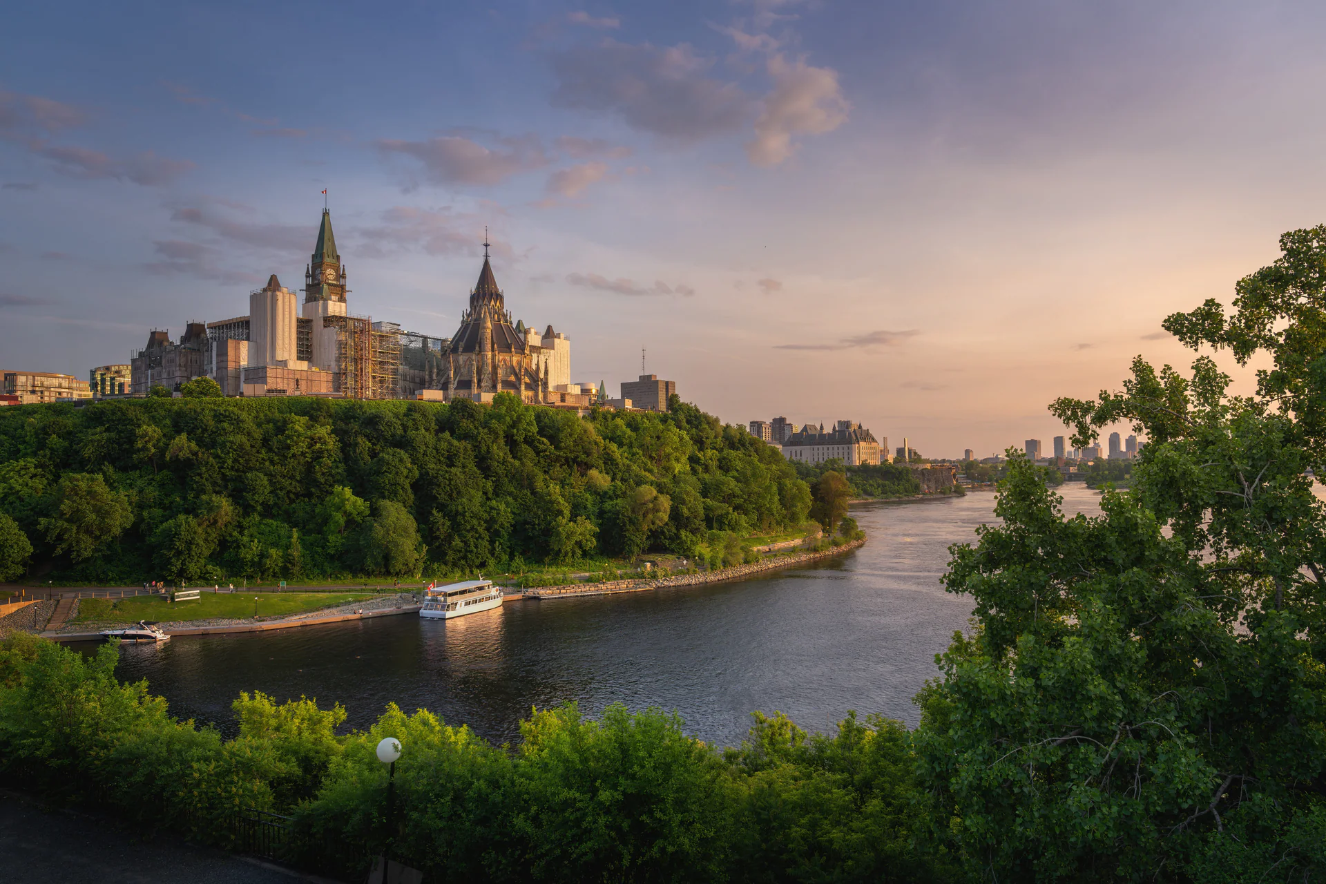 Ottawa skyline featuring Parliament Hill and the Ottawa River at sunset Ottawa skyline featuring Parliament Hill and the Ottawa River at sunset – Ottawa, Ontario, Canada.