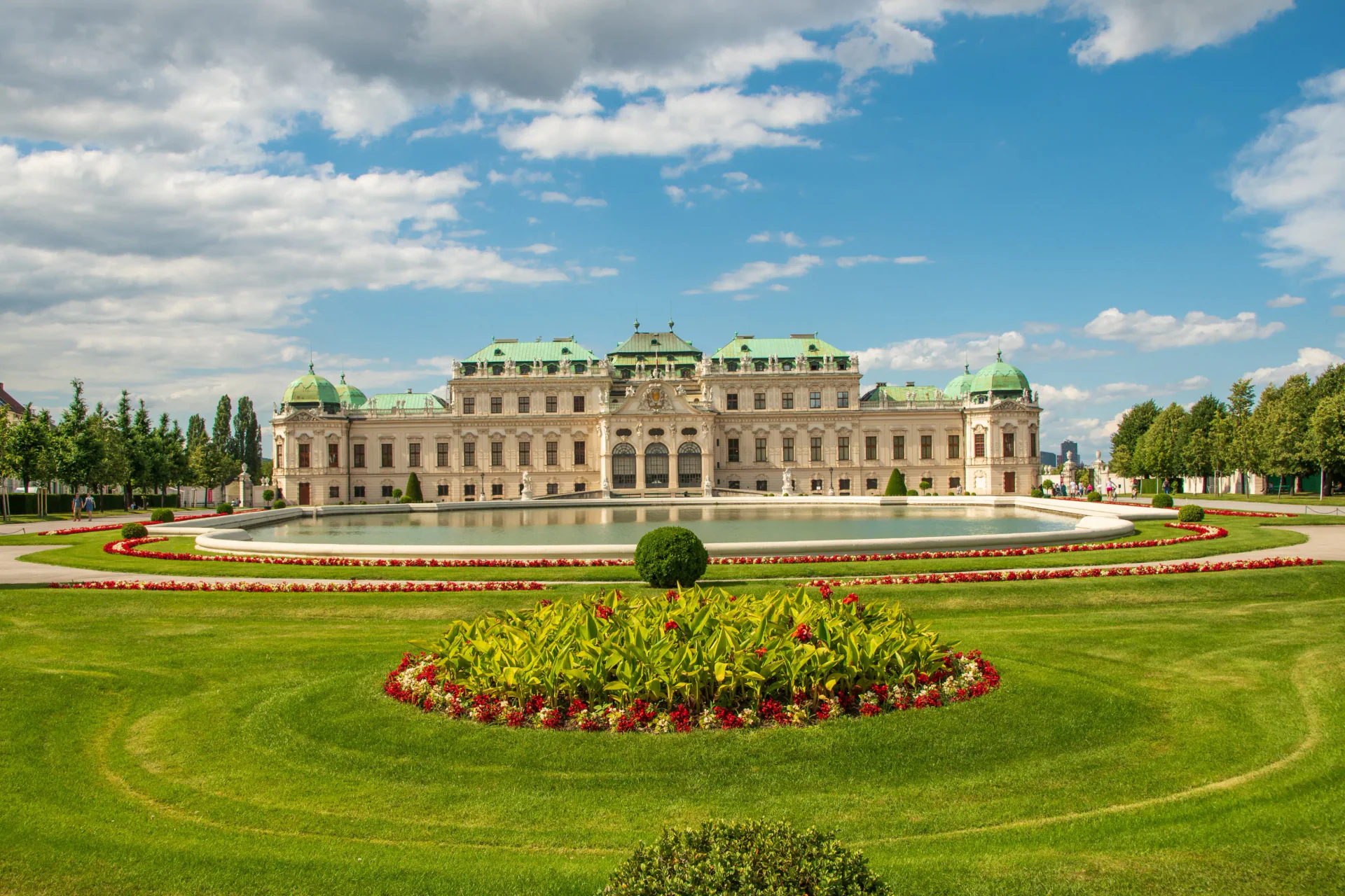 Una foto del Belvedere di Vienna mostra la sua imponente facciata barocca, con sculture ornate e giardini simmetrici che conducono al palazzo.
